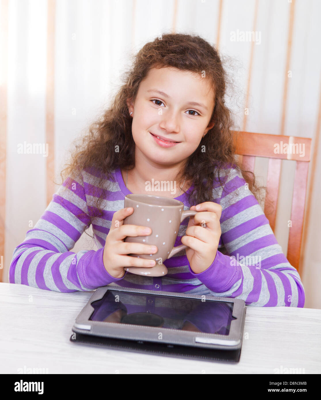 Little brunette girl using tablet computer Stock Photo - Alamy