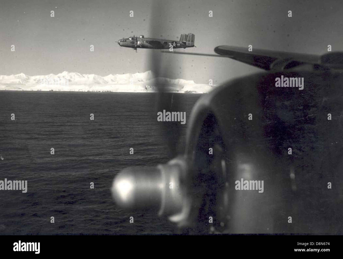 A World War II-era aircraft flies over the water, carrying out a ...