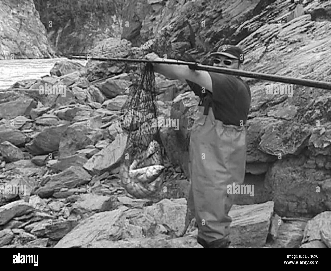 The image shows an Aleut subsistence fisherman holding a king chinook ...