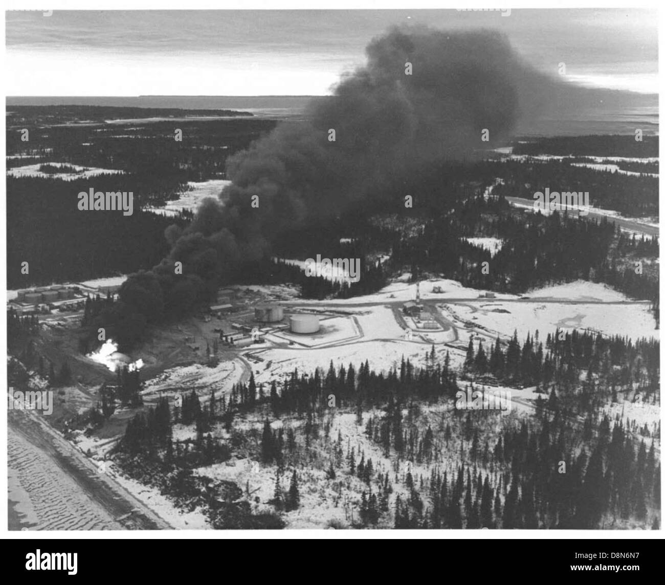 This black-and-white aerial photograph captures a burning landscape ...