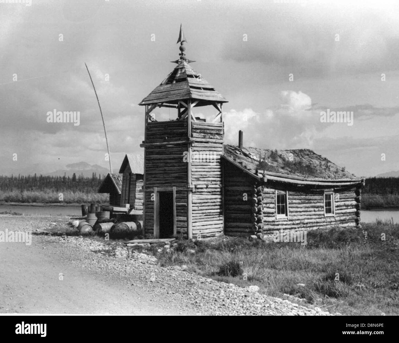 A black and white photograph of a traditional log church in a rural ...