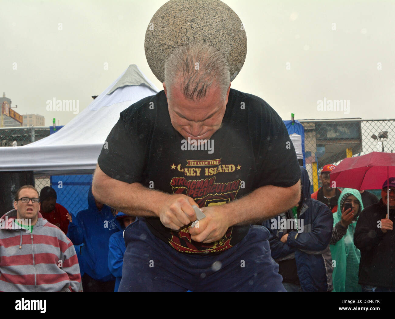 Steve Wiener rips a phonebook with a cement boulder on his shoulder at ...