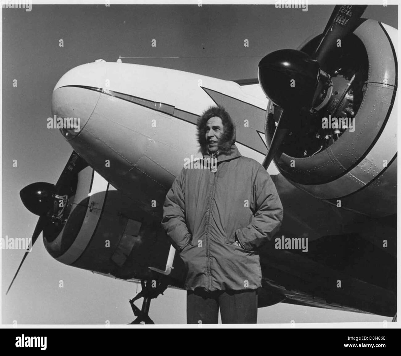 A man standing beside a vintage plane, showcasing the contrast between ...