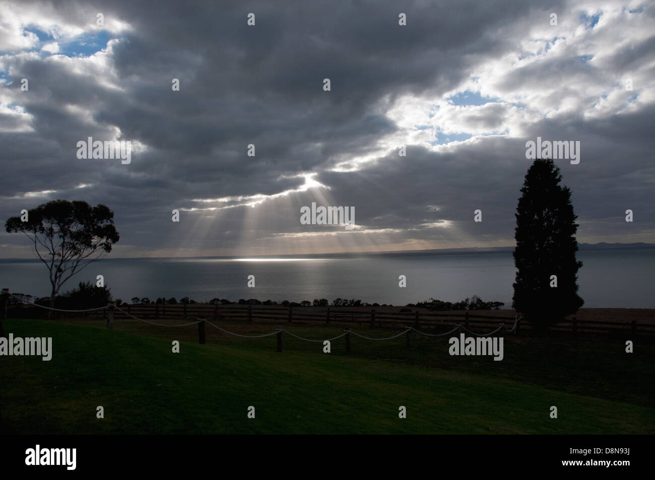 beams of light through storm clouds over the sea coast, ocean view calm ...