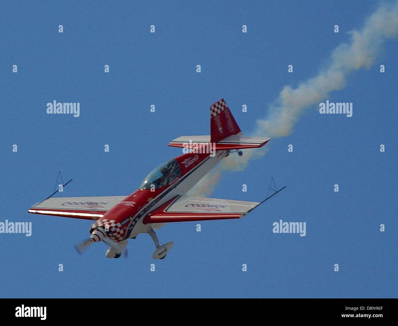 A stunt plane performs acrobatic maneuvers in the sky. The aircraft is ...