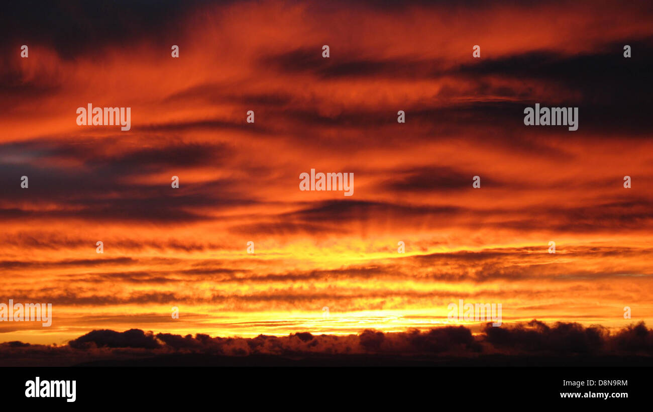 A scenic sunset with the sun setting below the horizon, casting warm ...