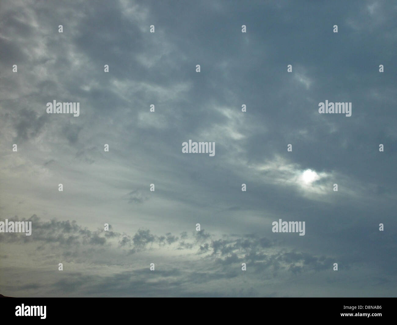 Sun peering through thick cloud cover Stock Photo - Alamy