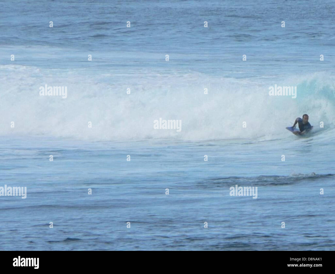 This image shows a surfer riding a wave, capturing the moment of action ...