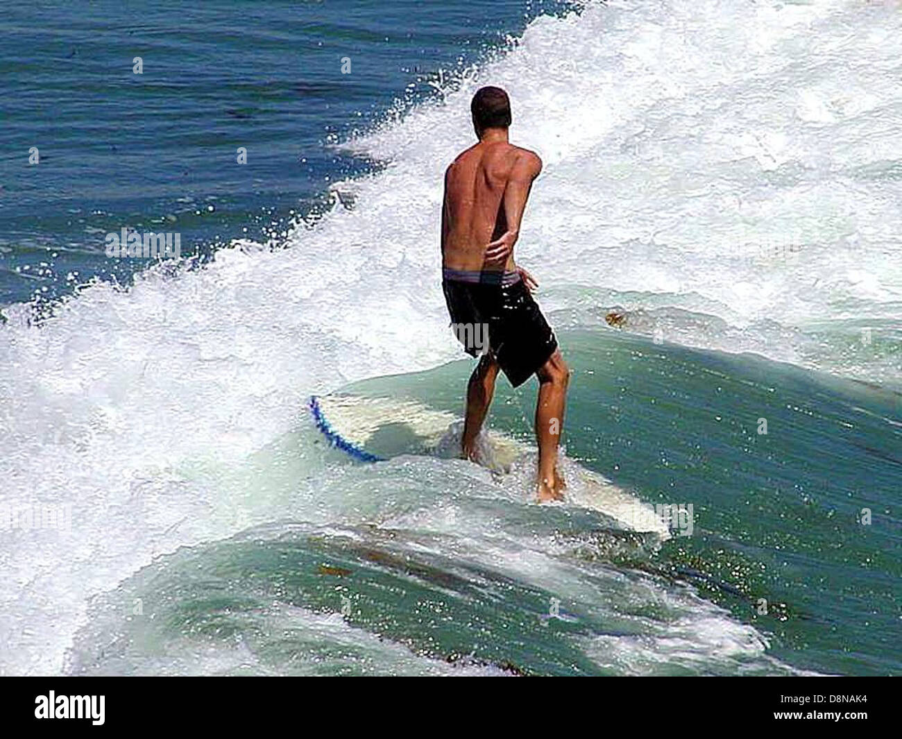 This photo captures a surfer riding the waves on a clear ocean day. The ...