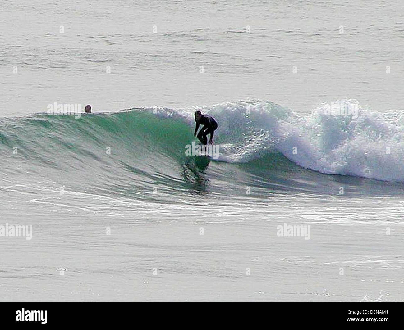 Surfers ride the waves in the ocean, capturing the dynamic and exciting ...