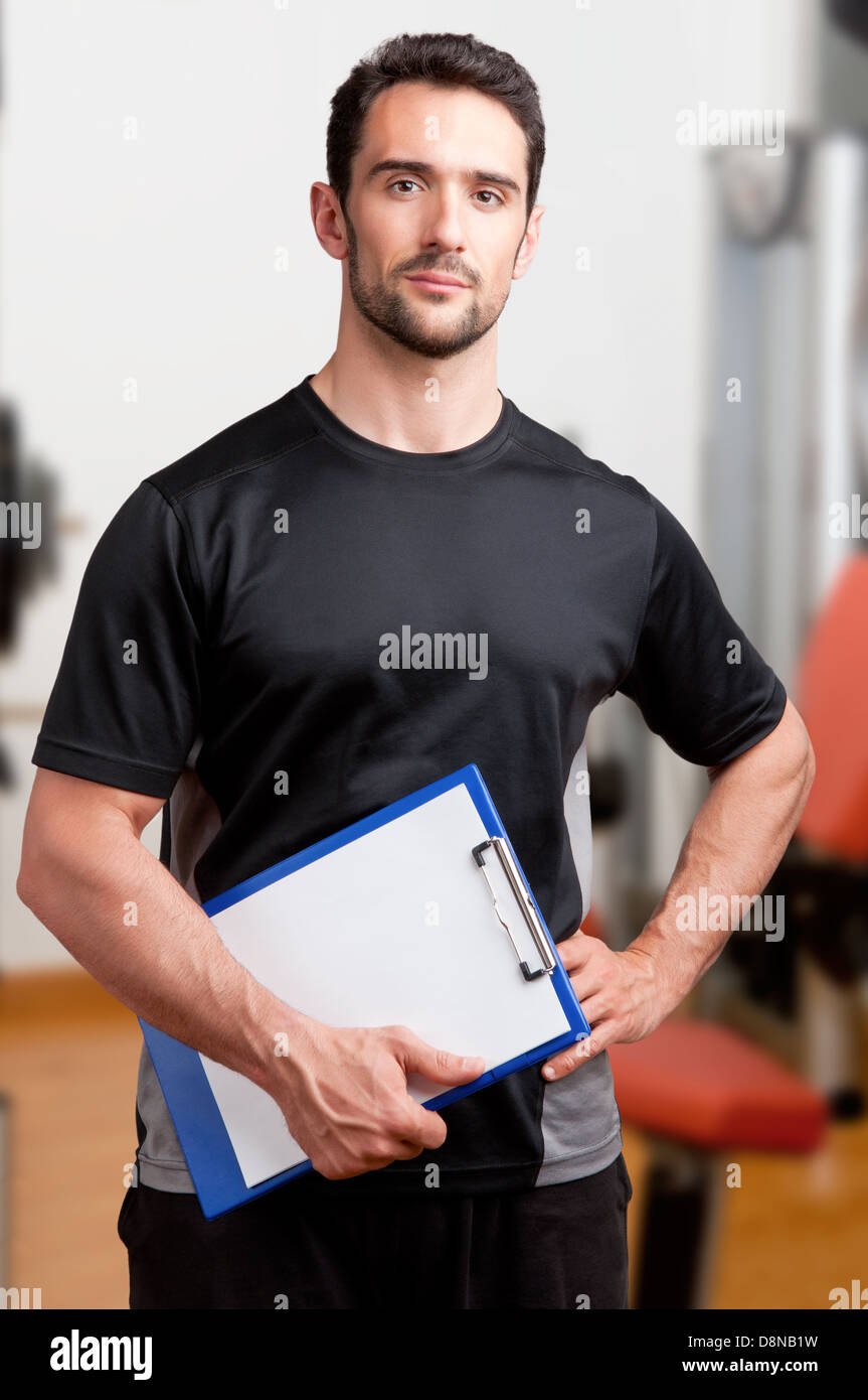 Personal Trainer, with a pad in his hand, in a gym Stock Photo - Alamy