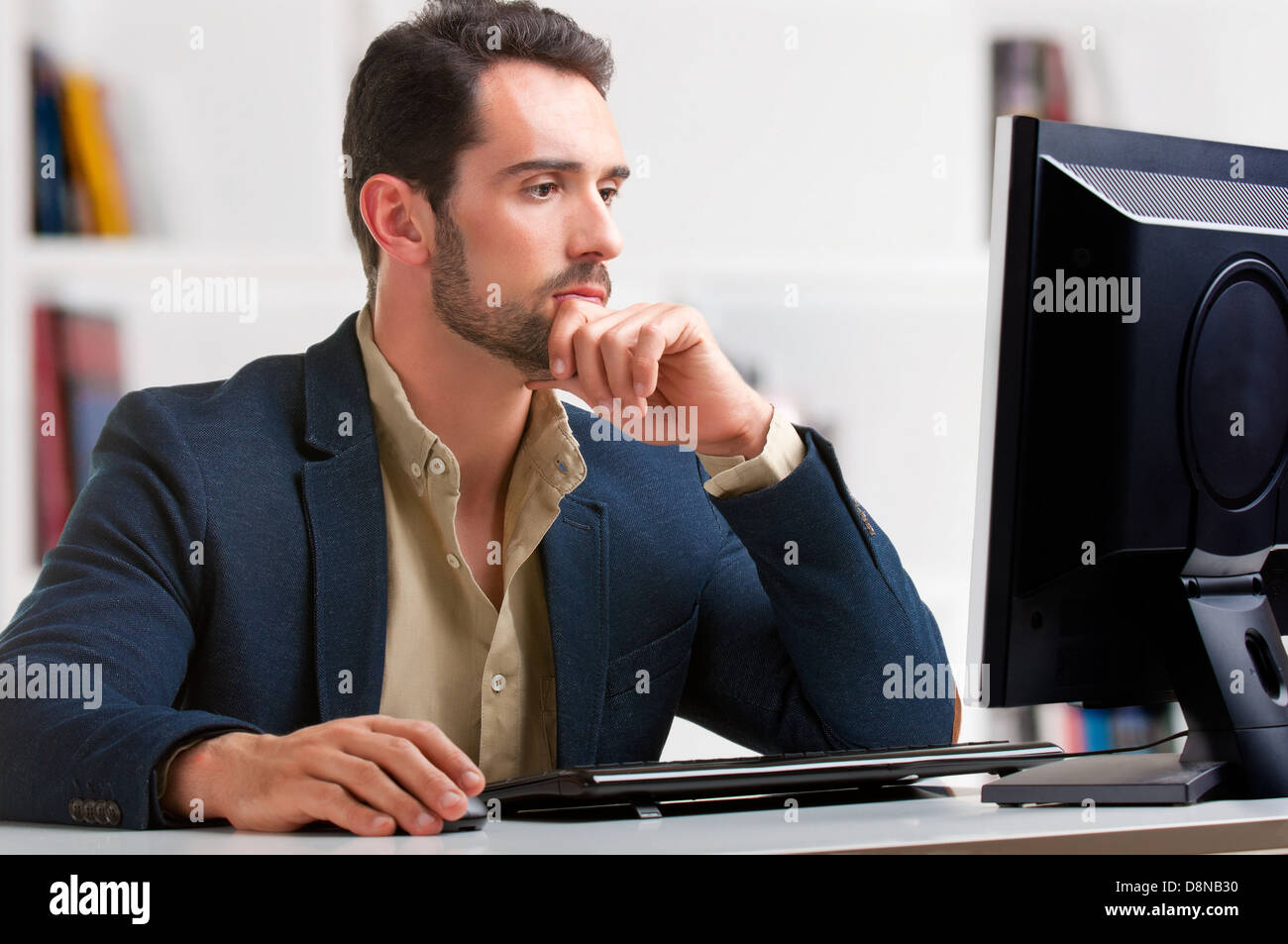 Man looking at a computer screen, thinking about the job at hand Stock ...