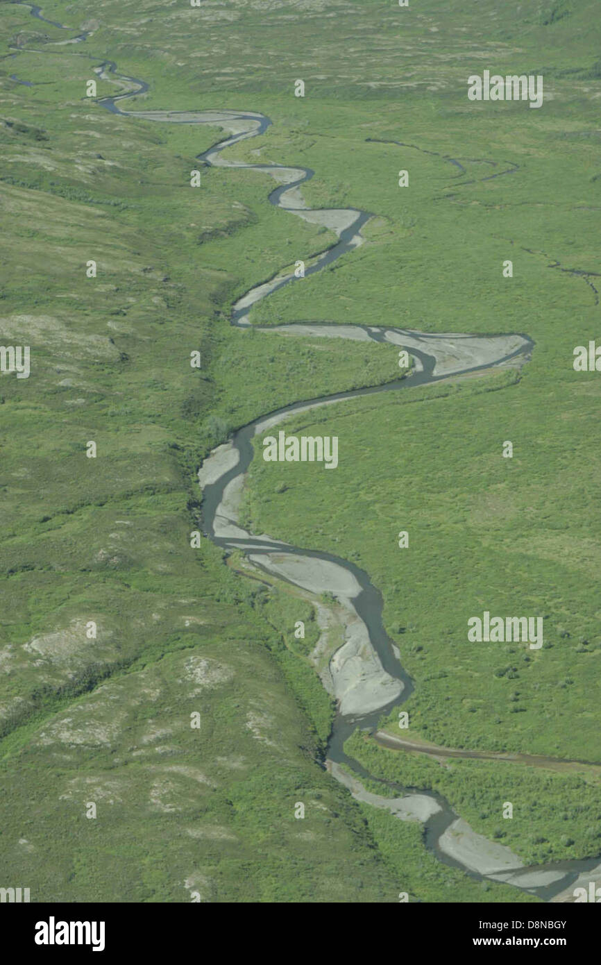 An aerial view of a tight, winding river cutting through mountain flats ...