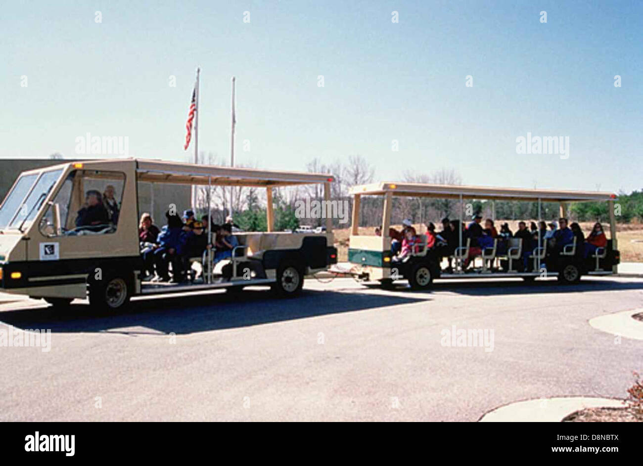 A group of tourists takes a ride on an open tram tour, exploring a ...