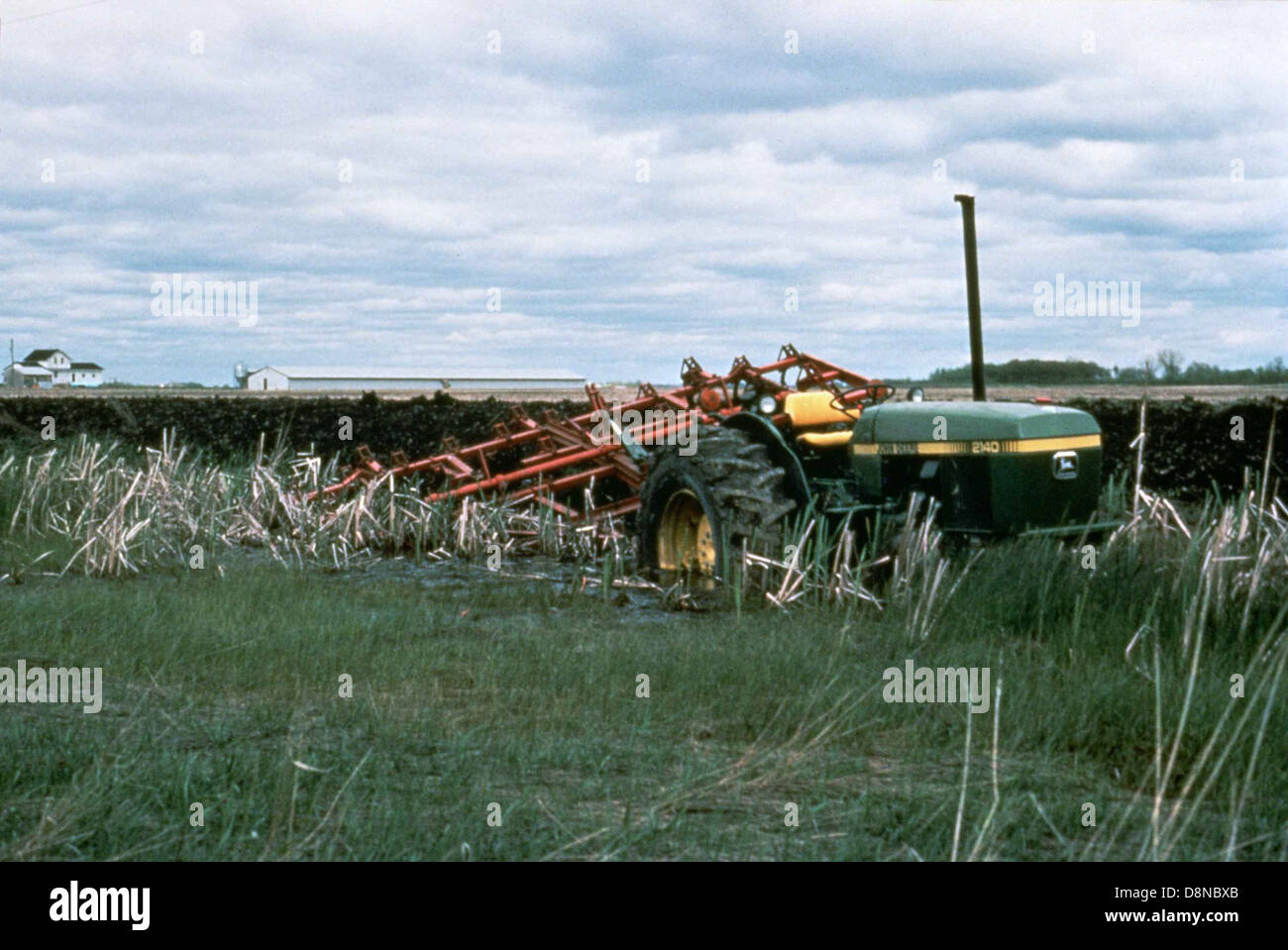 A tractor stuck in a wetland area while attempting to plow ...