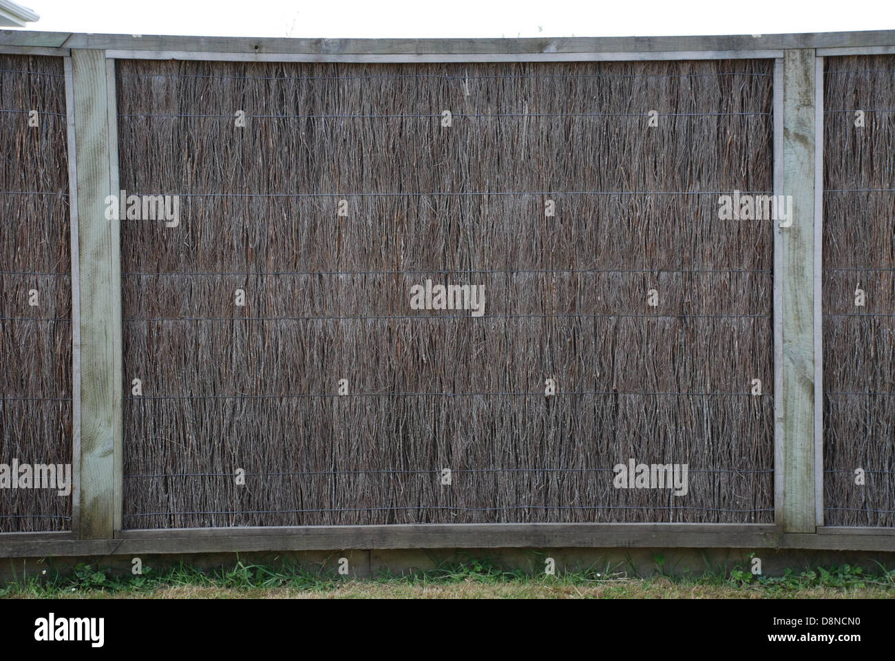 A twig fence is made from thin, interwoven branches and twigs, creating ...