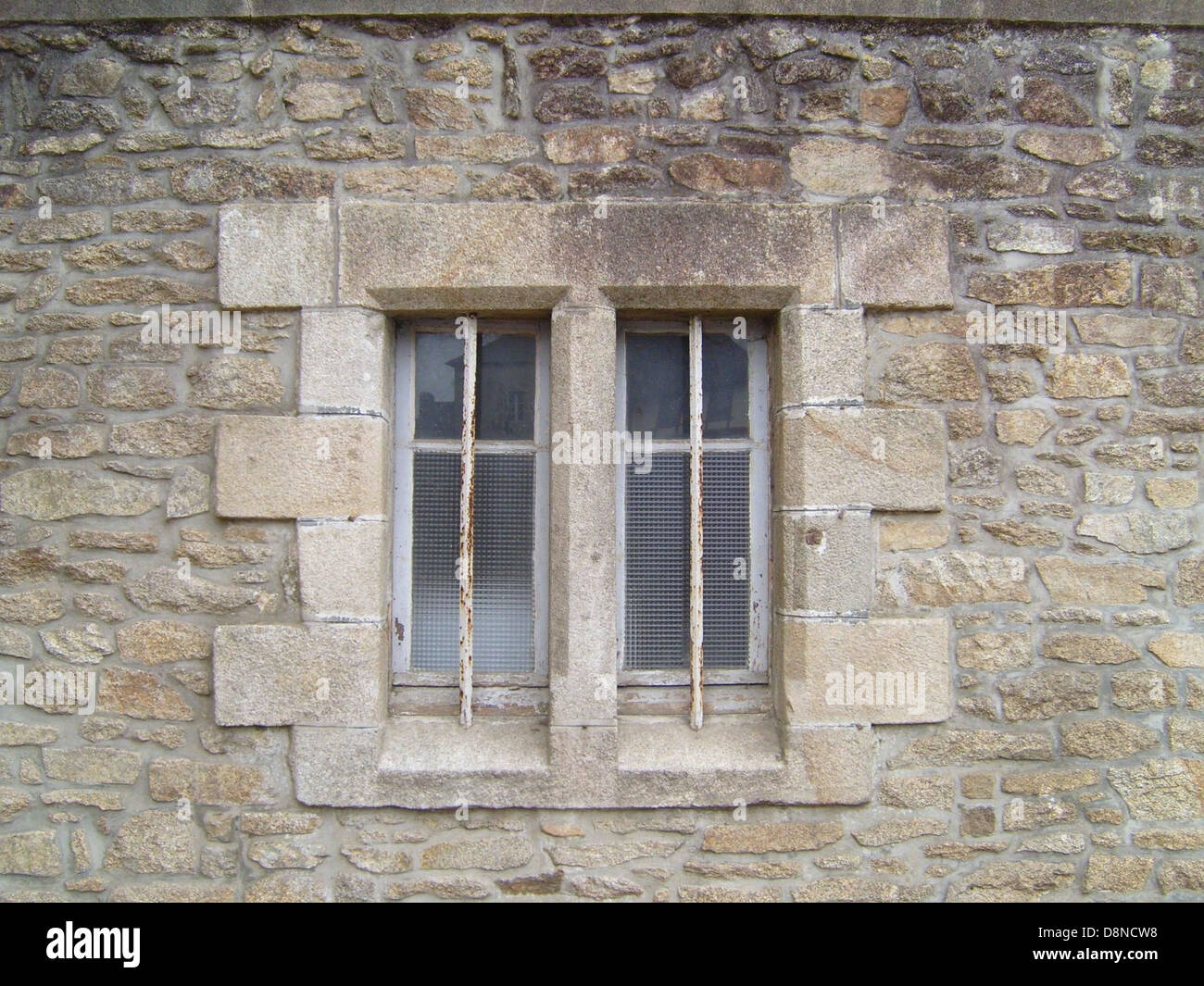 A close-up of two old, weathered windows on a house, showing signs of ...