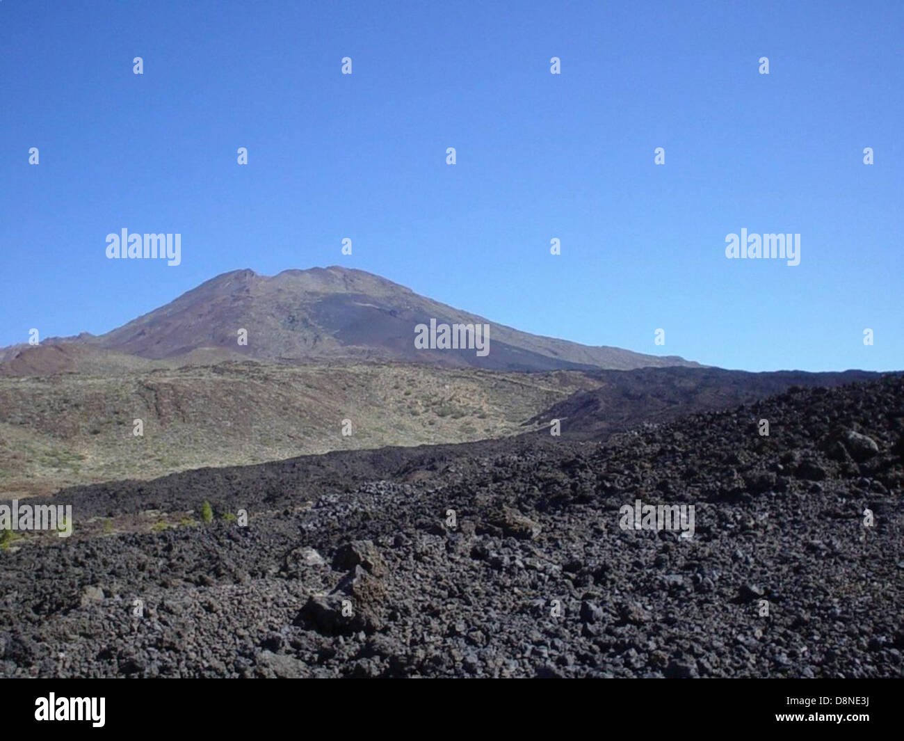 A majestic volcanic mountain stands tall, with signs of past eruptions ...