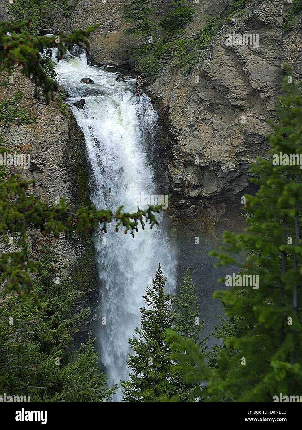 This image shows a towering waterfall cascading down, creating a ...