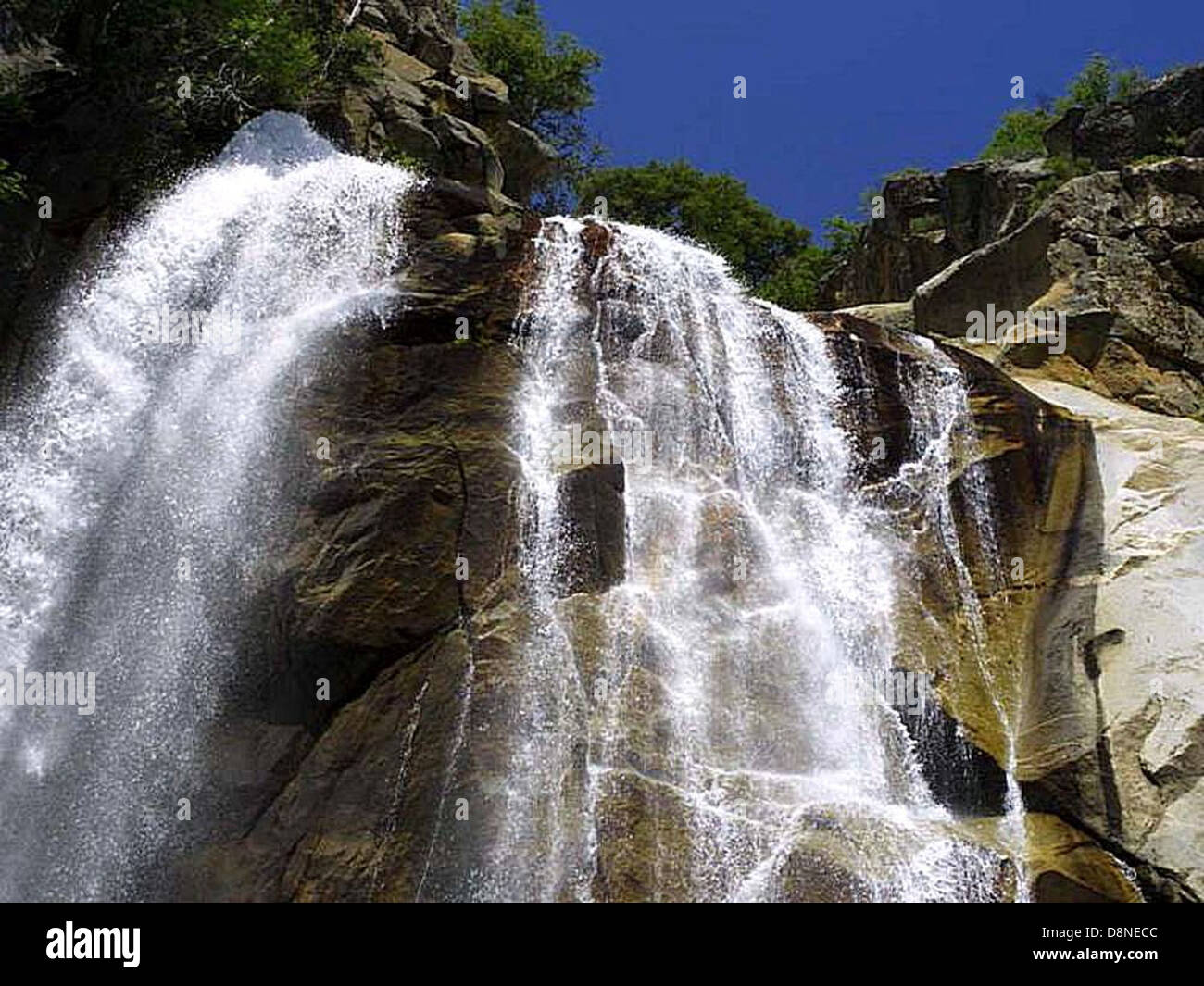 A stunning waterfall cascades over rocks, creating a scenic view. The ...