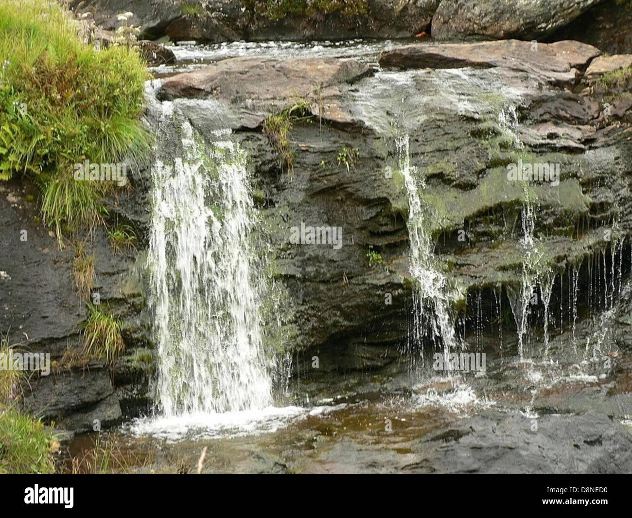 A waterfall cascading into a waterstream, with water flowing down rocks ...