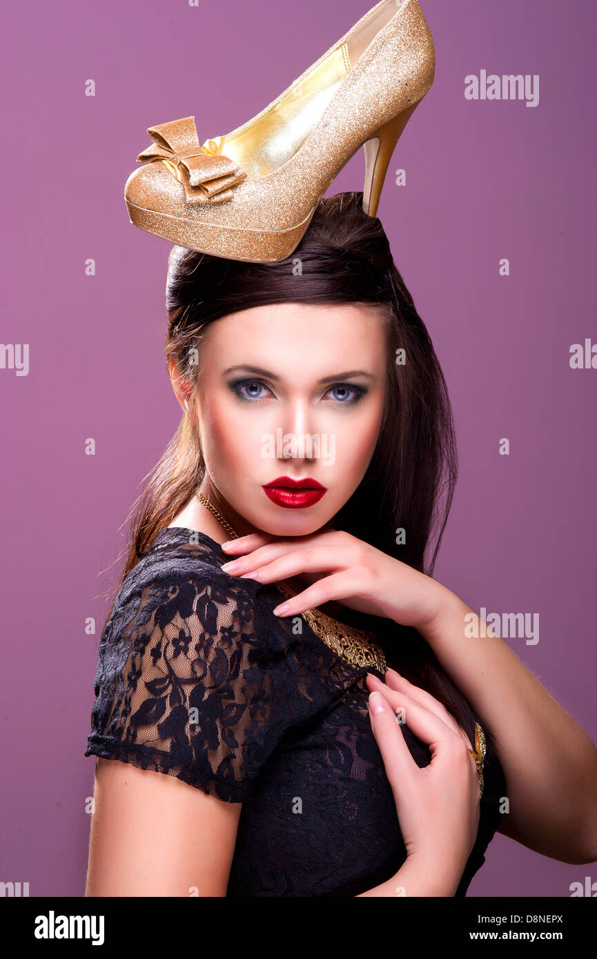 Sexy woman with gold shoe on head Stock Photo - Alamy