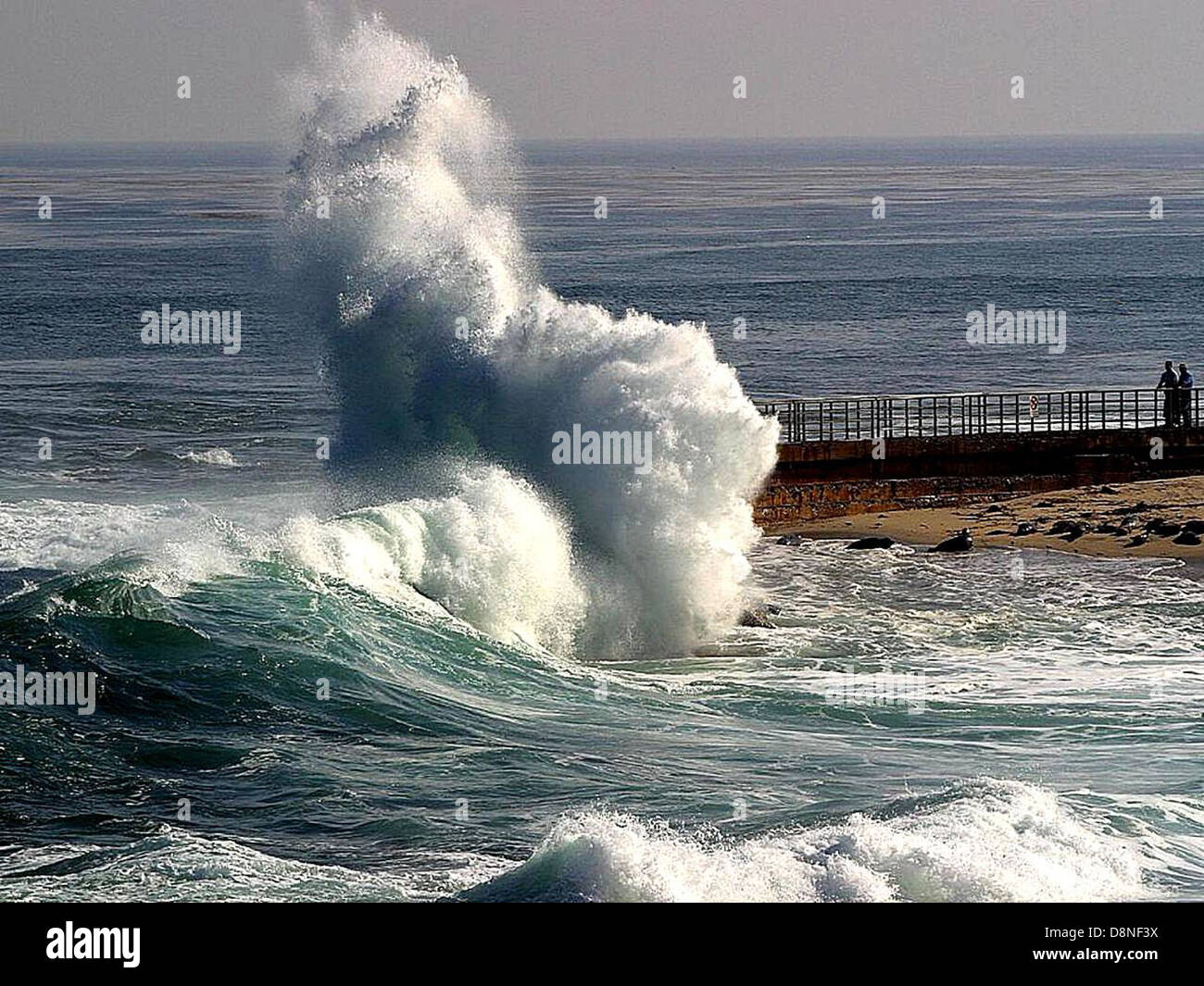 Powerful waves crash against the shore, creating a dramatic display of ...