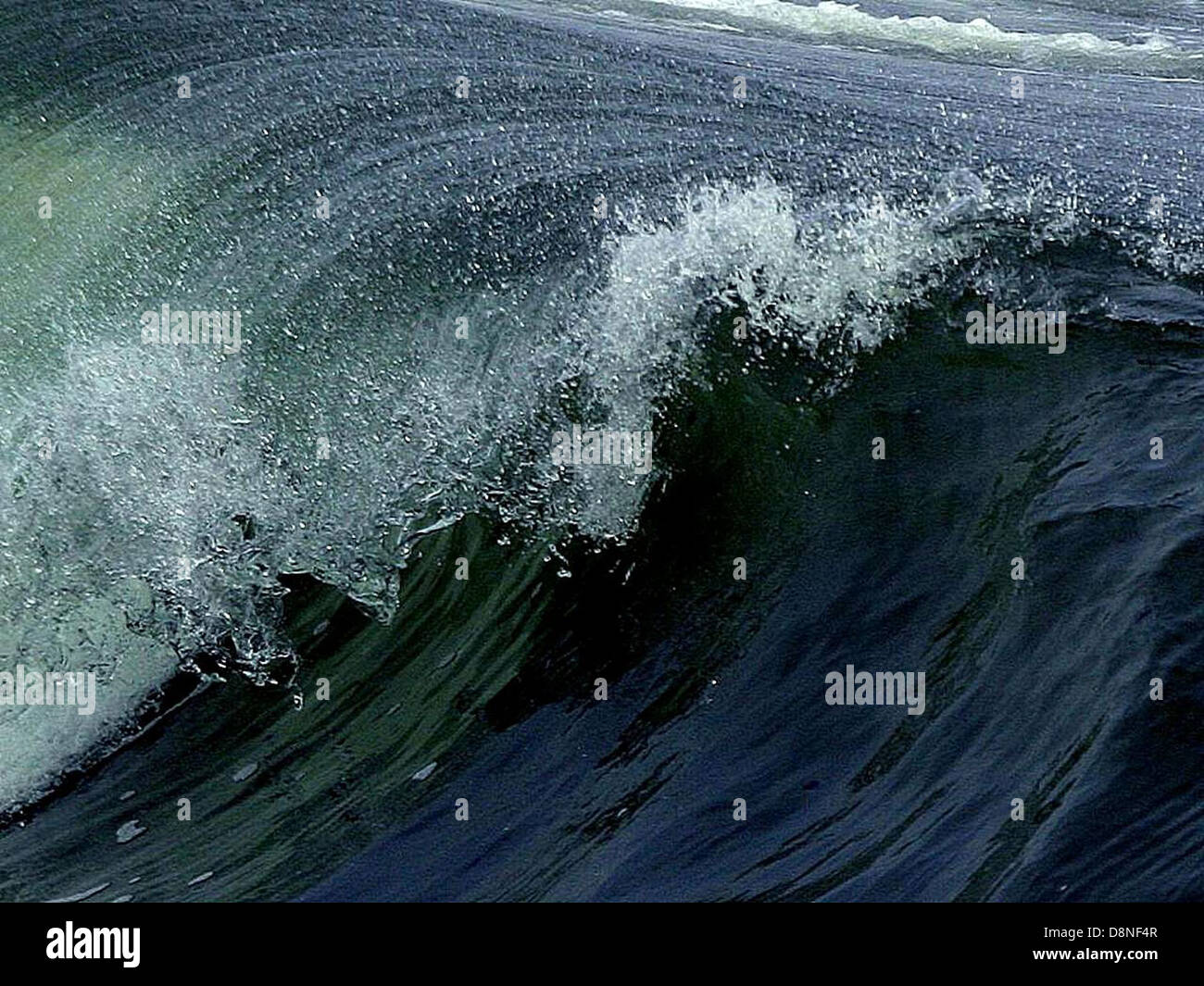 The ocean waves crash onto the shore, illustrating the dynamic movement ...
