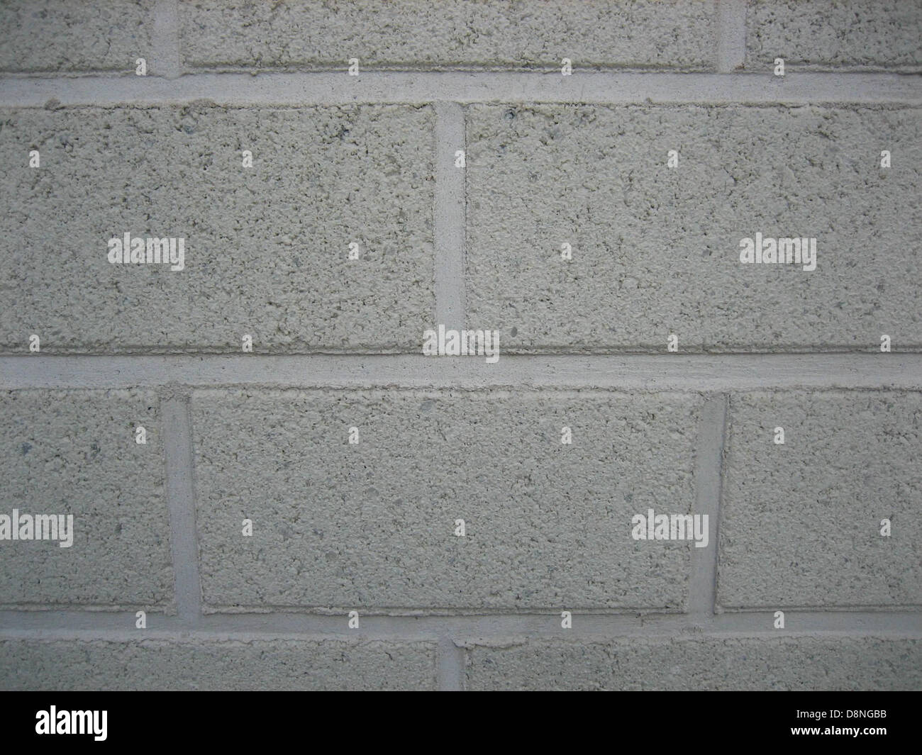 A clean and solid white stone brick wall, featuring uniform bricks in a ...
