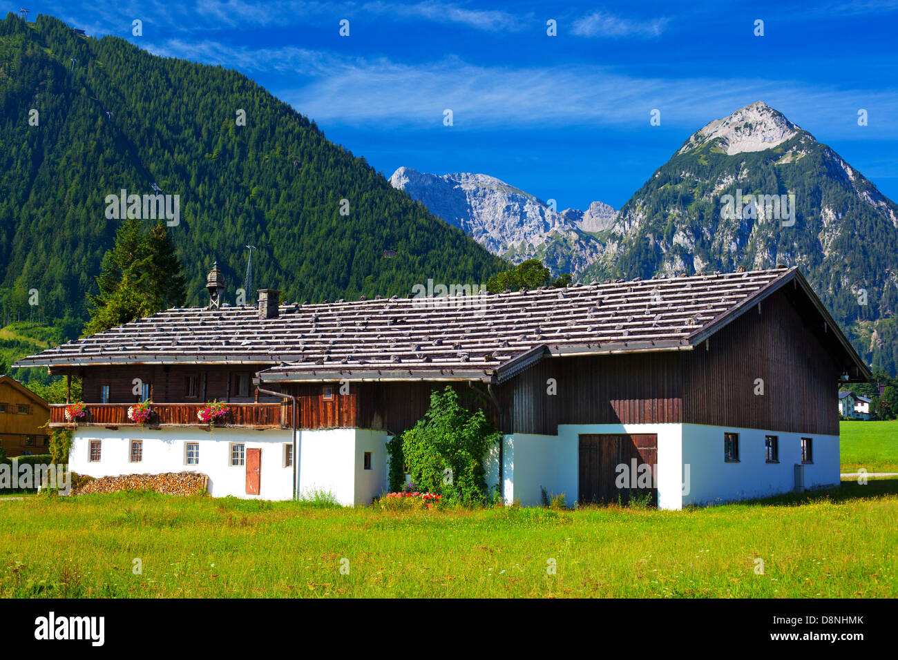 Traditional house on Alps mountains background Stock Photo - Alamy