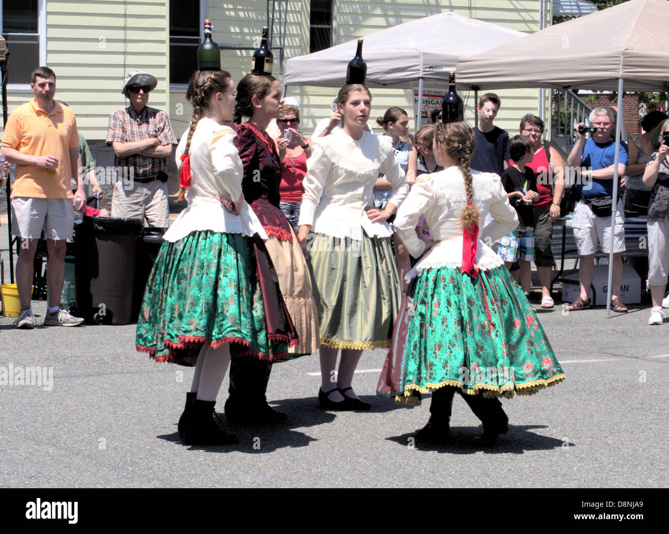 Girls in traditional Hungarian Dress dancing with bottles on their ...