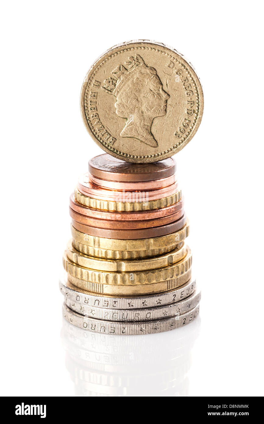 British pound coin on the stack of euros and euro cents on white ...