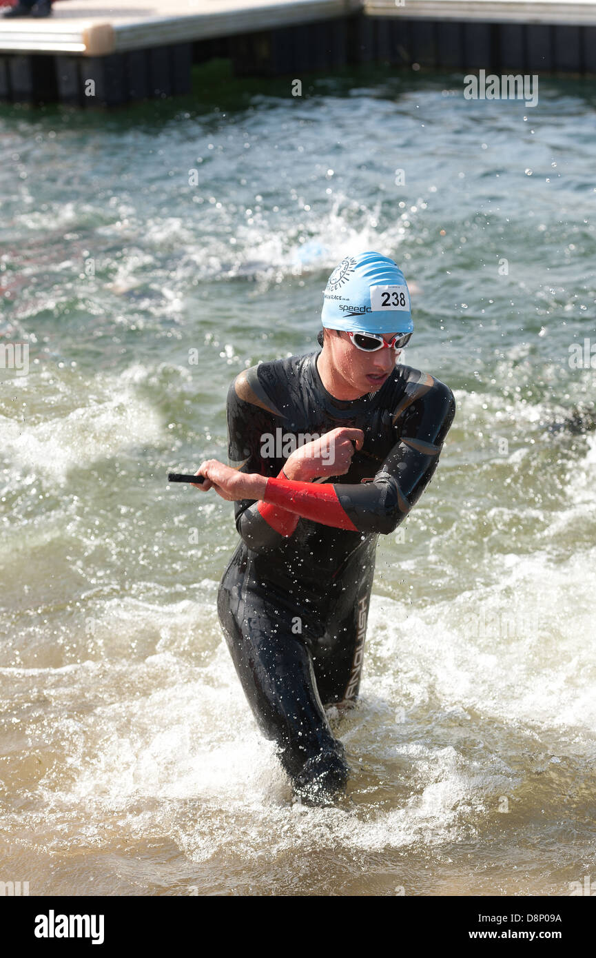 Male swimmer running from lake in triathlon transition open water ...