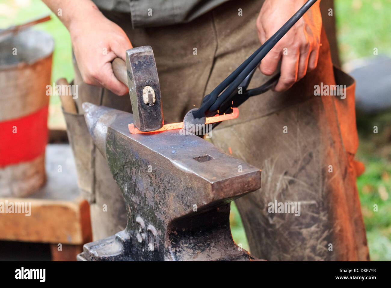 A smith forging a horse shoe on an anvil Stock Photo - Alamy