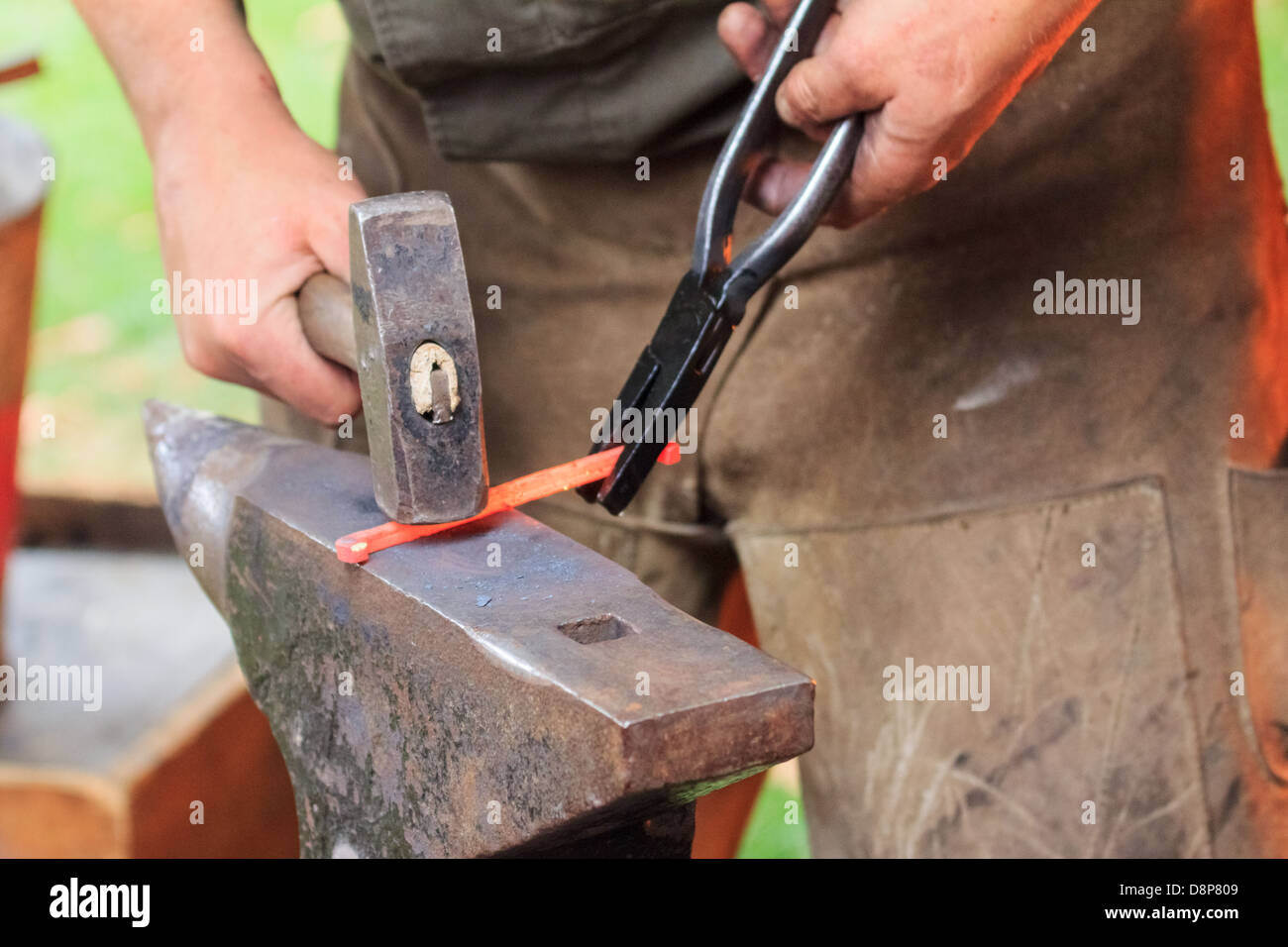 A smith forging a horse shoe on an anvil Stock Photo - Alamy