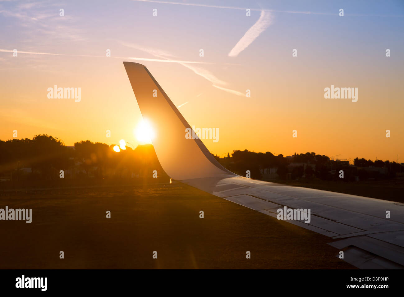 Airplane jet wing at sunset with golden light sun reflection Stock ...