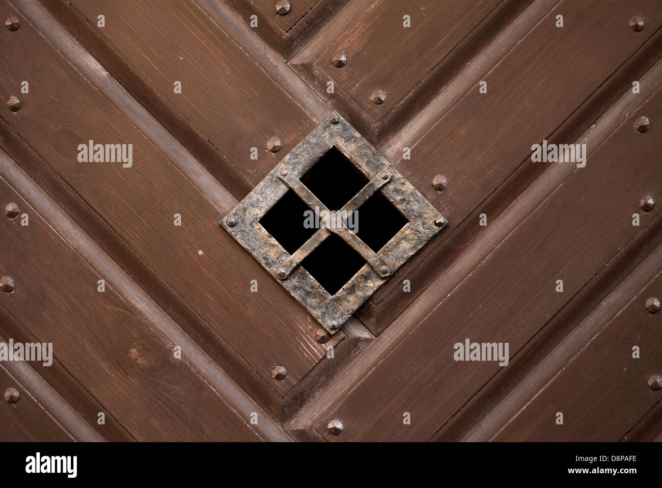Small viewing window with grid in old brown wooden door Stock Photo - Alamy