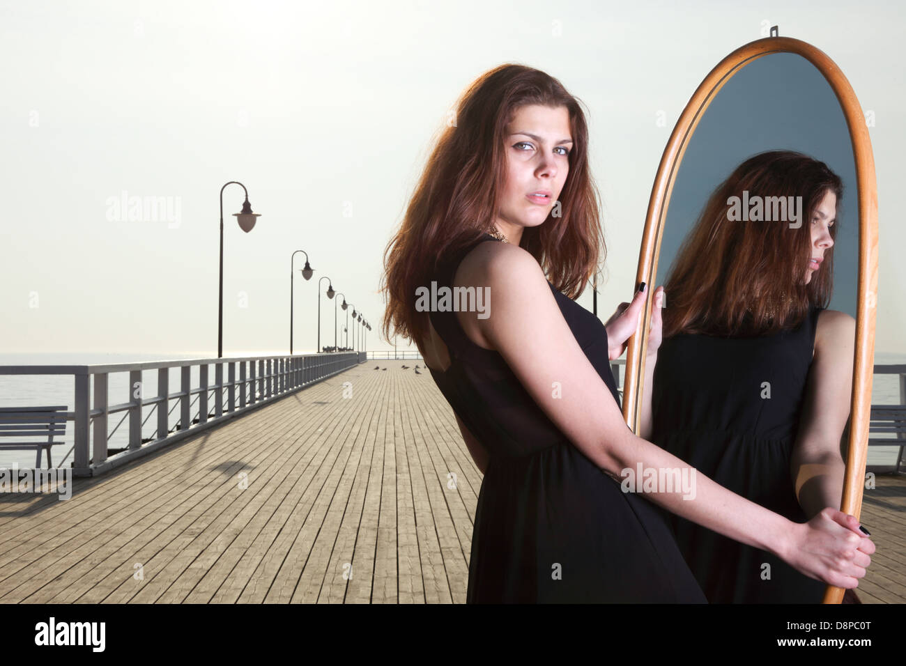 thoughtful young woman looks at the reflection in the mirror - solitude ...