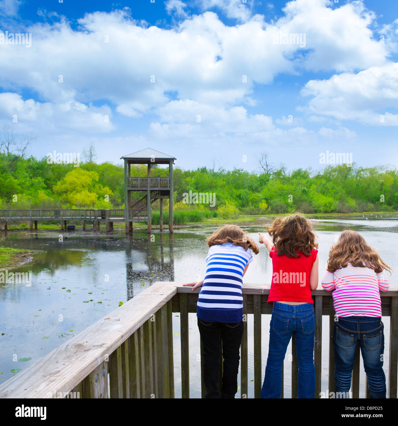 kid children girls looking and pointing at park lake in Texas rear view ...