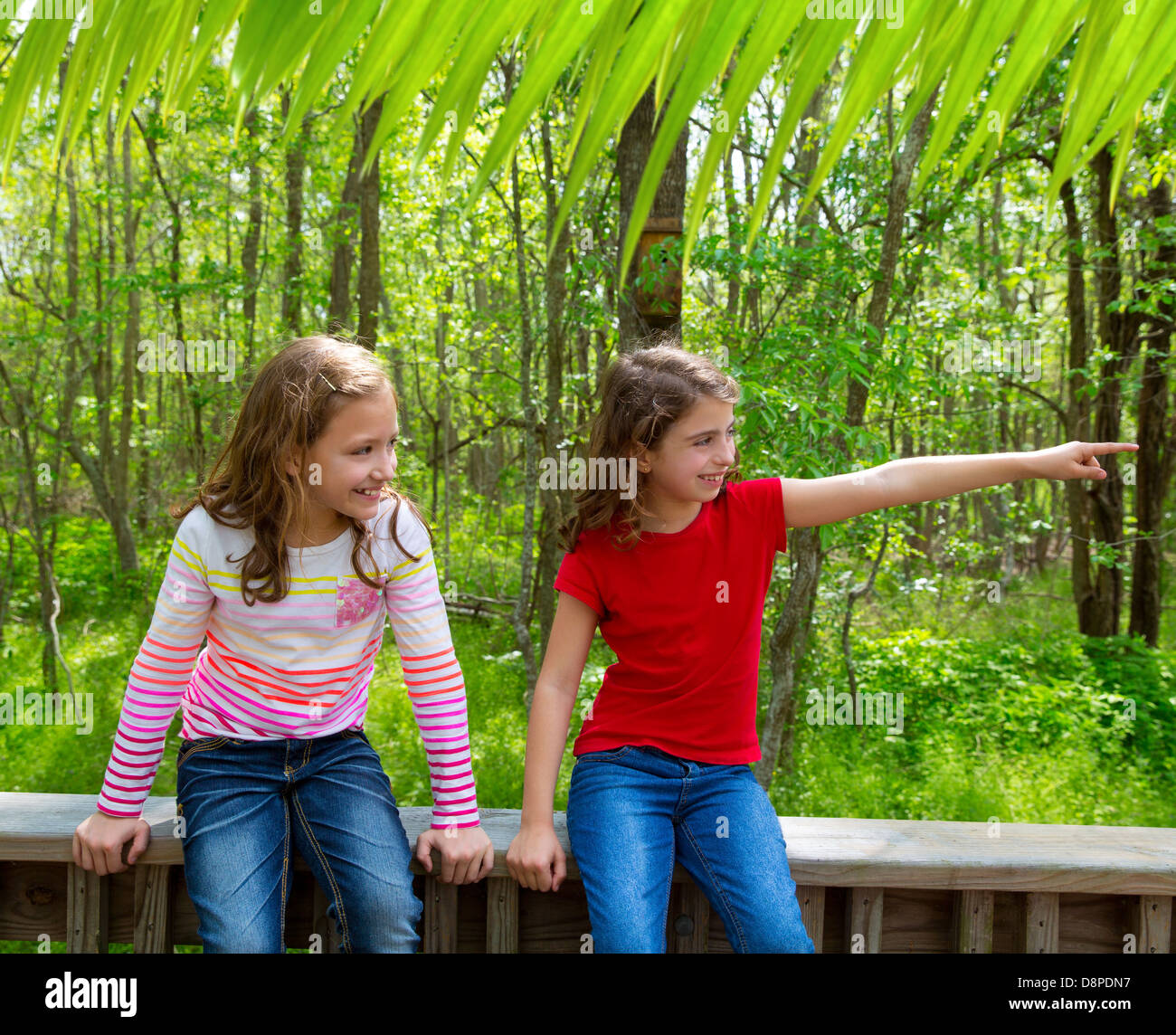 children sister friends playing relaxed pointing finger to jungle park ...