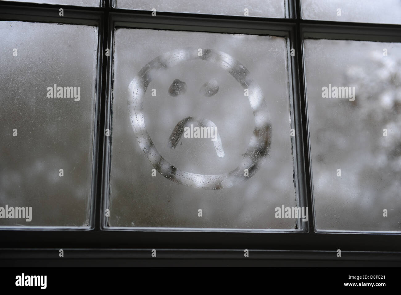 sad smiley face drawn in condensation on a window pane uk Stock Photo ...