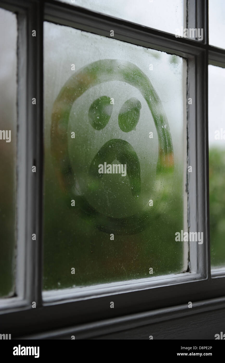 sad smiley face drawn in condensation on a window pane uk Stock Photo ...