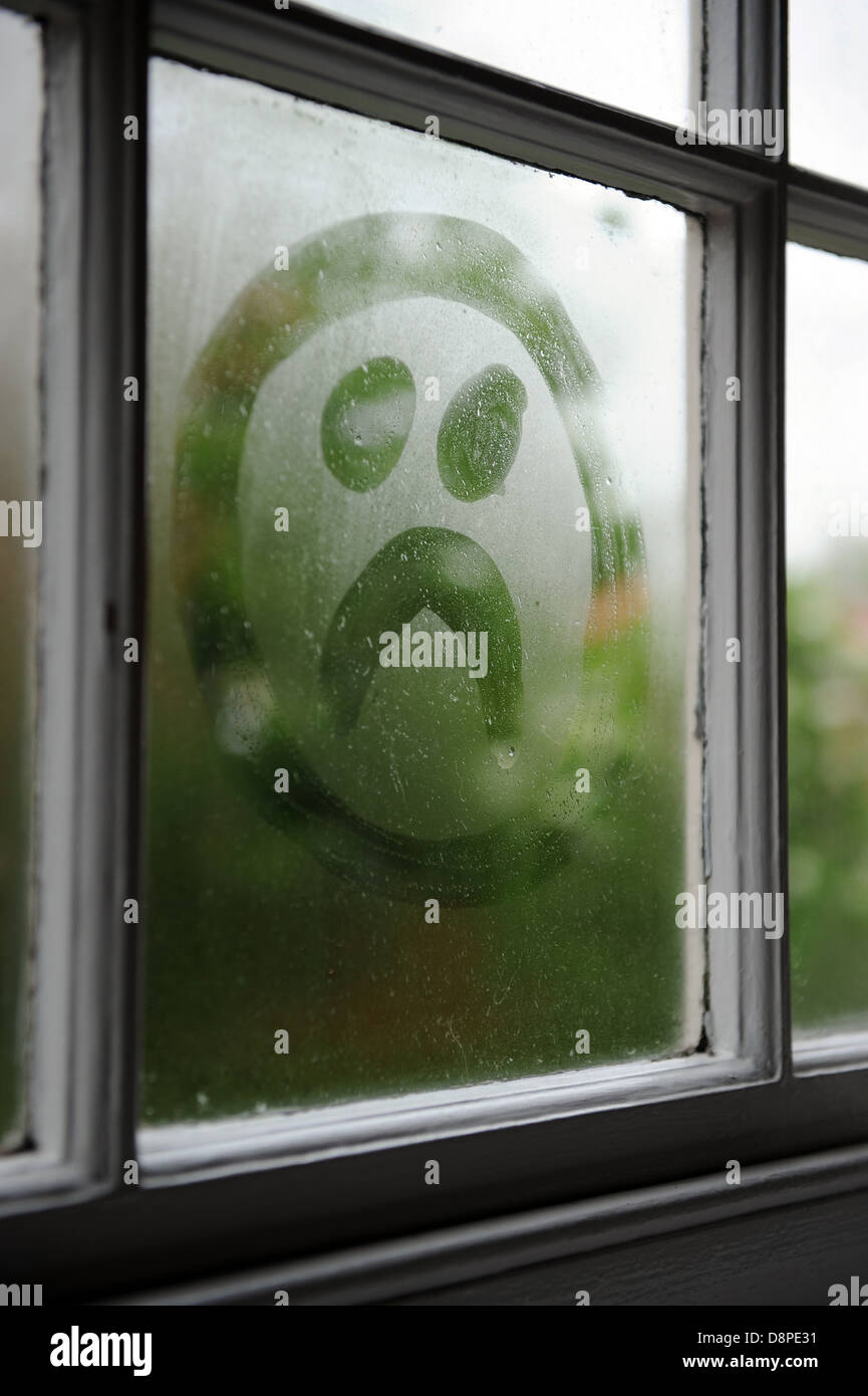 sad smiley face drawn in condensation on a window pane uk Stock Photo ...