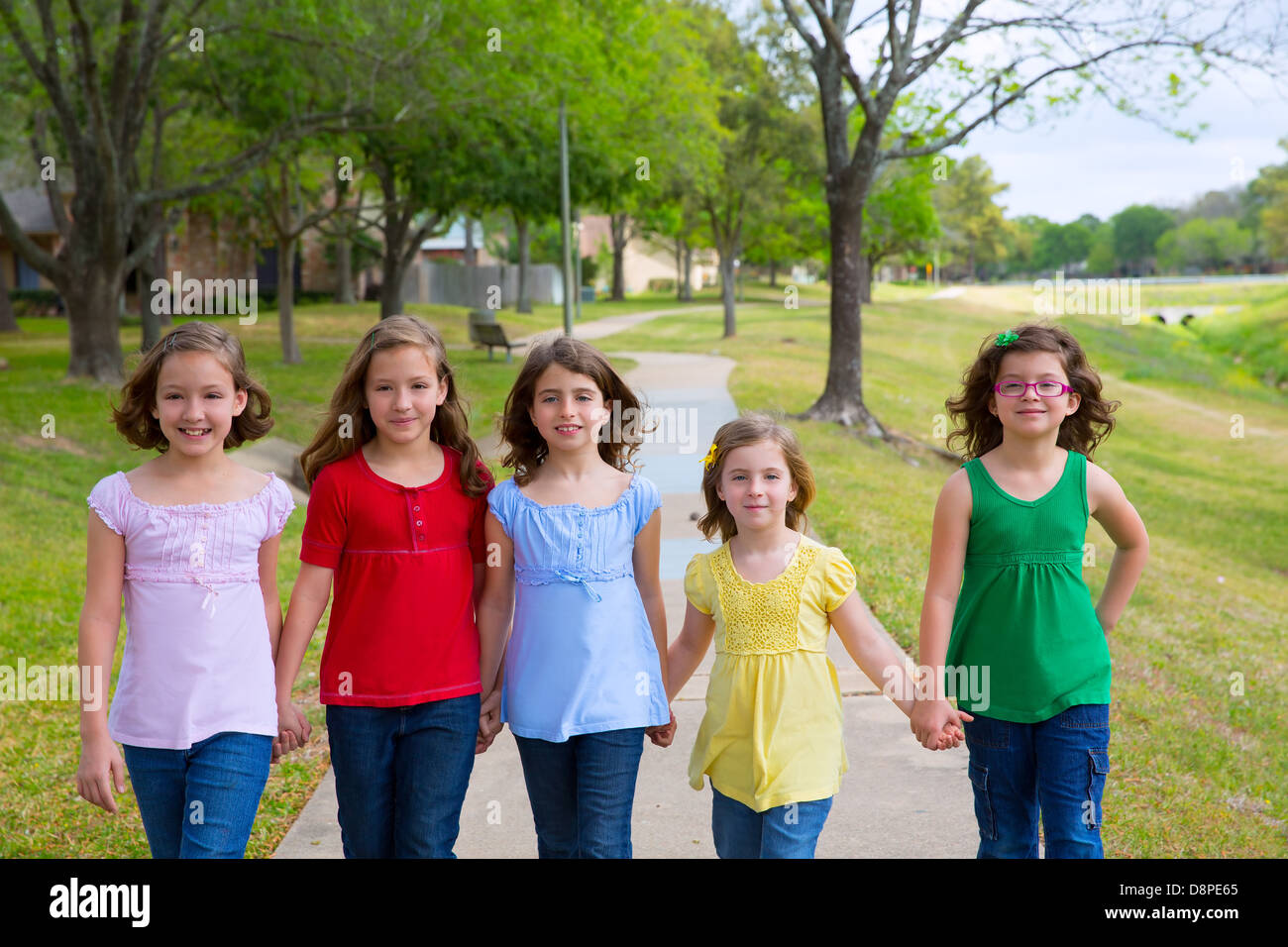 Children group of sisters girls and friends walking happy in the park ...