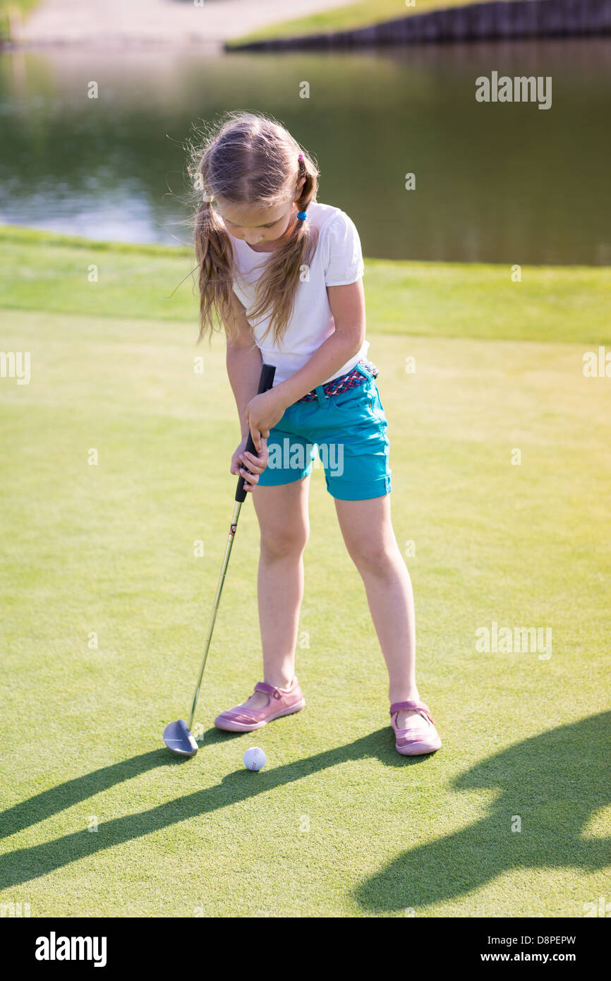Cute little girl playing golf on a field outdoor Stock Photo - Alamy