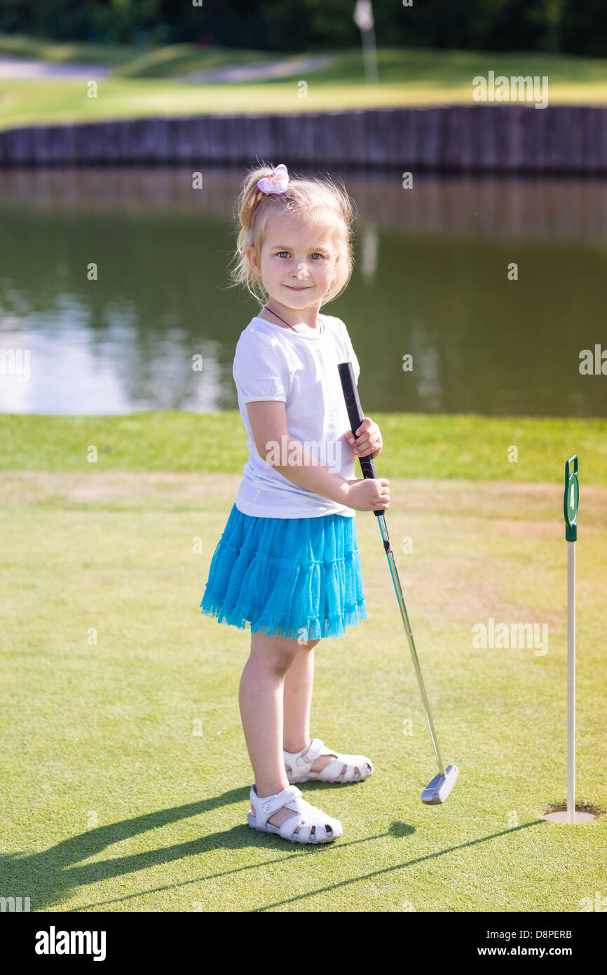 Cute little girl playing golf on a field outdoor Stock Photo - Alamy