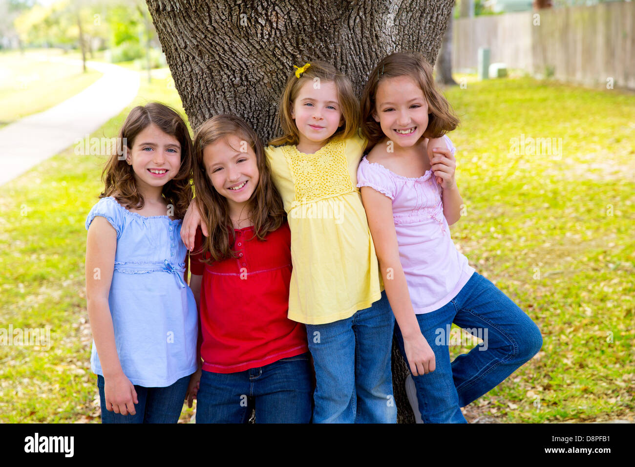 Children group friend girls friends playing on tree trunk at the park ...