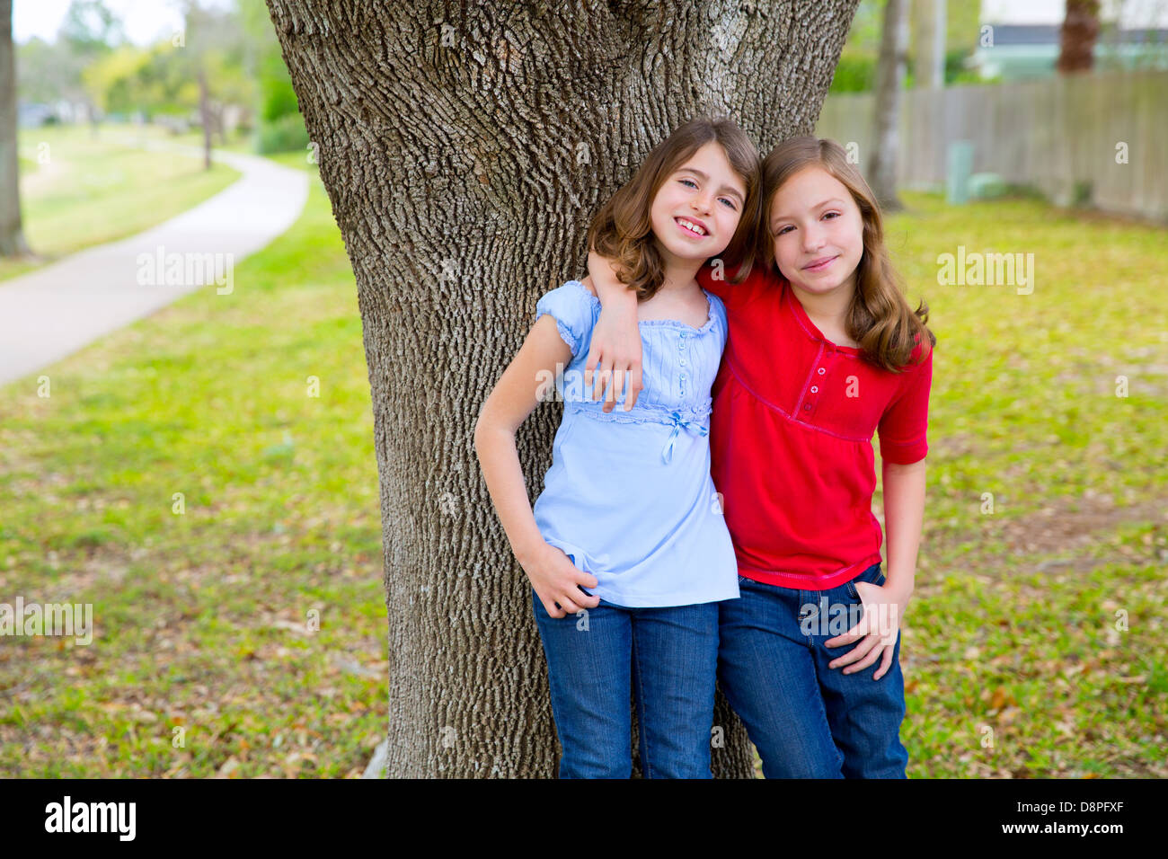 children kid friend girls hug relaxed happy smiling in a park tree ...
