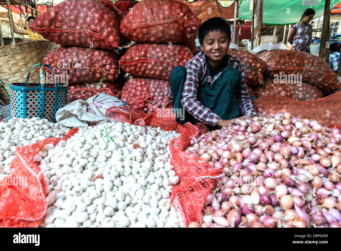 Young Burmese boy selling onions and garlic at local food street market ...