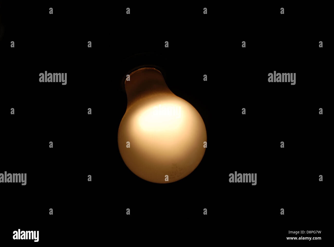 Weak yellow light bulb glowing in darkness Stock Photo - Alamy